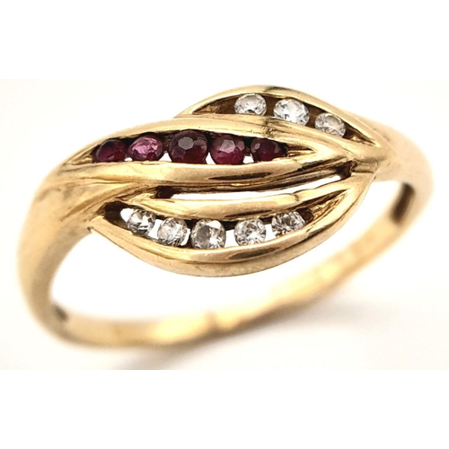 A 9K YELLOW GOLD DIAMOND & RUBY TWIST RING - 1.6G. SIZE O