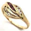 A 9K YELLOW GOLD DIAMOND & RUBY TWIST RING - 1.6G. SIZE O