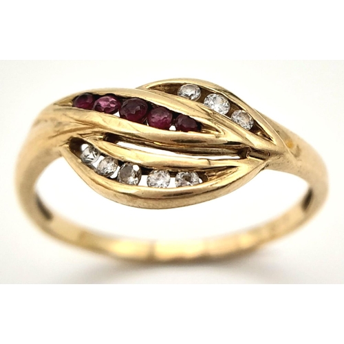 A 9K YELLOW GOLD DIAMOND & RUBY TWIST RING - 1.6G. SIZE O