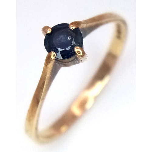 A 9K GOLD RING WITH A CLAW SET SAPPHIRE SOLITAIRE STONE. 1.4gms size M