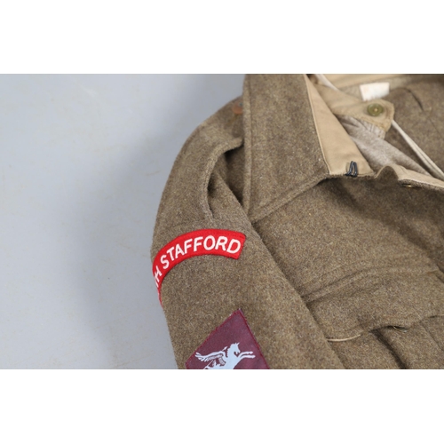 A COLLECTION OF SECOND WORLD STYLE BATTLE TUNICS AND TROUSERS. A ...