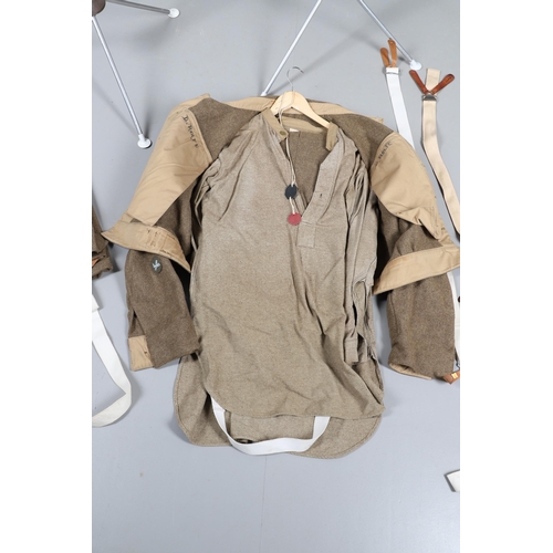 A COLLECTION OF SECOND WORLD STYLE BATTLE TUNICS AND TROUSERS. A ...