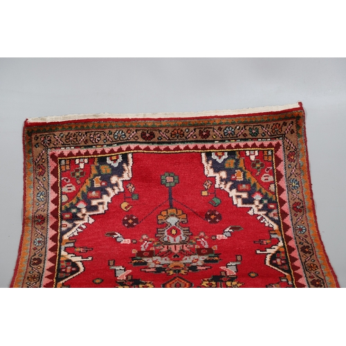 A HAMADAN RUNNER. The raspberry field with an ivory central medallion ...