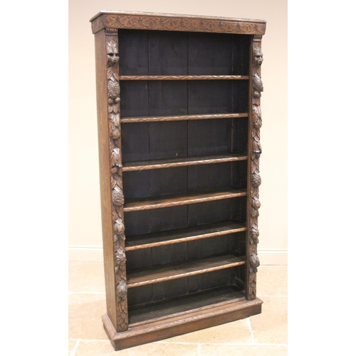 A Victorian carved oak open bookcase, the pediment with incised lunette ...