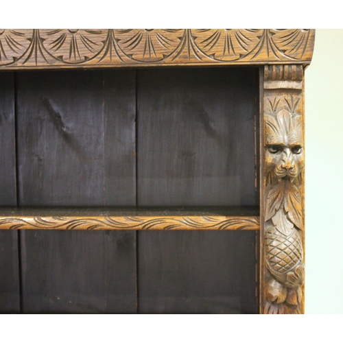 A Victorian carved oak open bookcase, the pediment with incised lunette ...