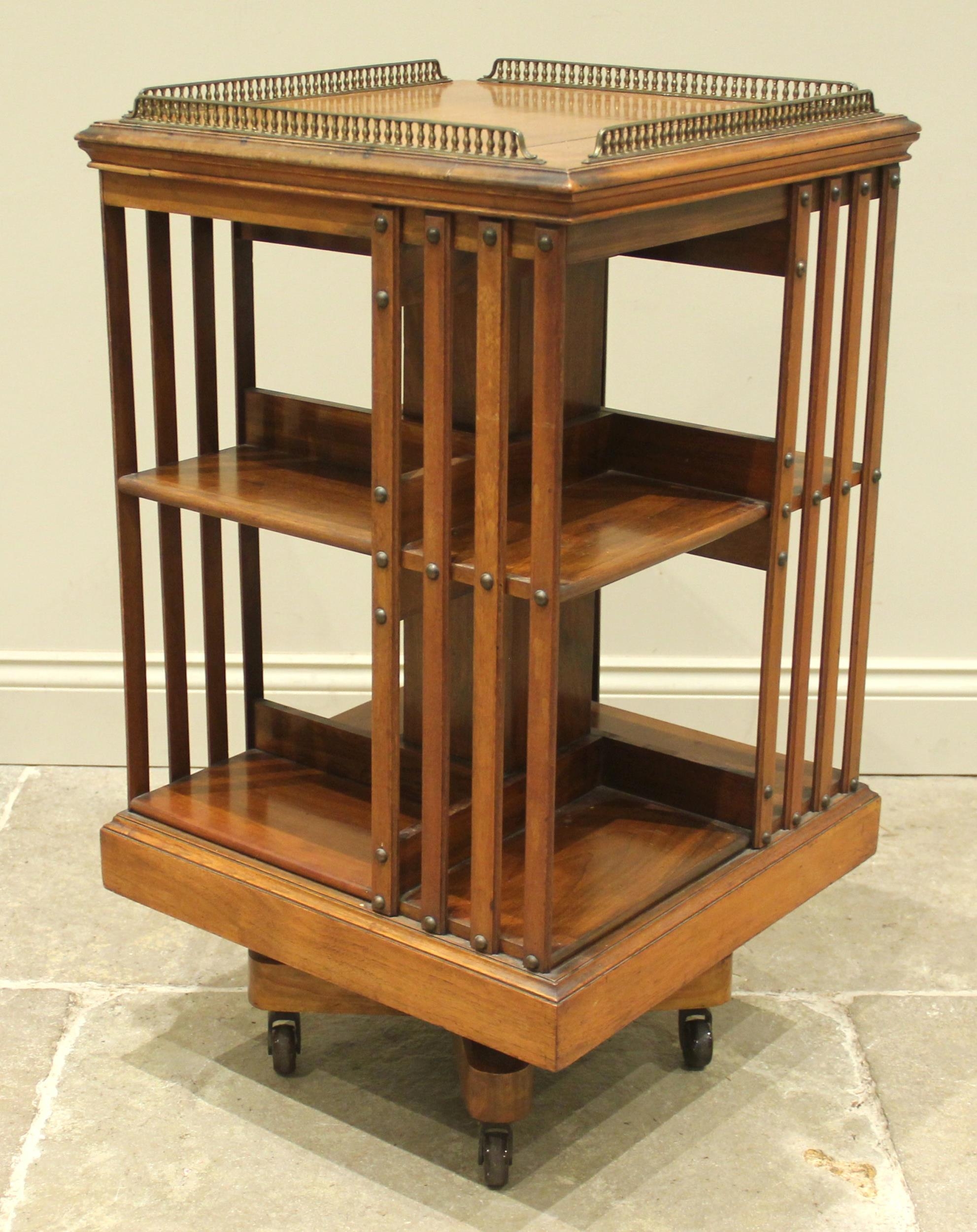 An Edwardian walnut revolving library bookcase, the moulded upper tier ...