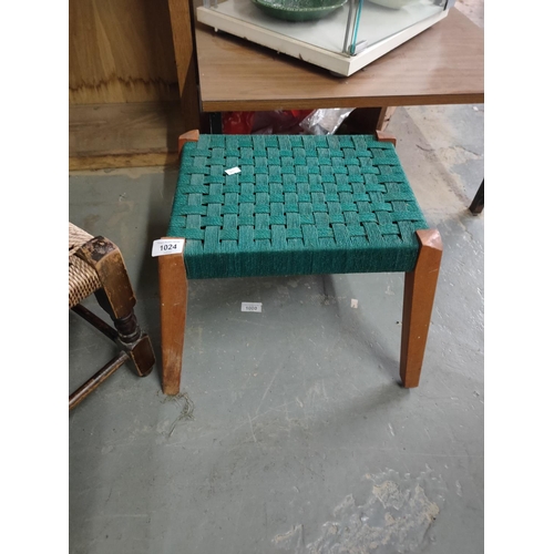 A retro wooden stool with green string mesh seat