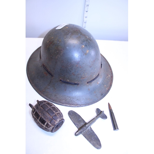 A WW2 British tin helmet dated 1941, with inert mills grenade, inert ...
