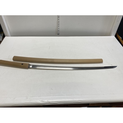 An antique hand forged Japanese Katana sword, in a wooden scabbard ...