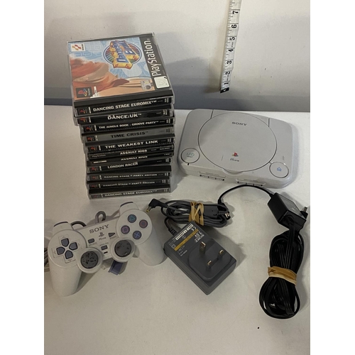 A Sony PS1 with controller and accessories with a selection of games