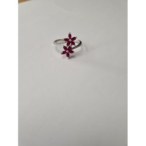 18ct white dress ring with two ruby inset flower heads of cross over ...