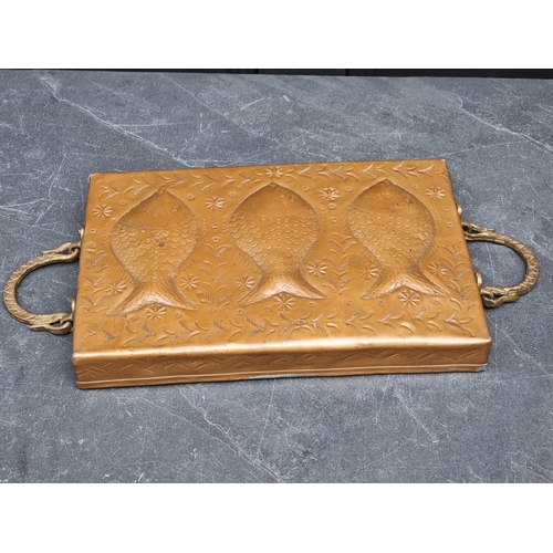 A Newlyn copper twin handled tray, repousse decorated with fish, 32cm ...