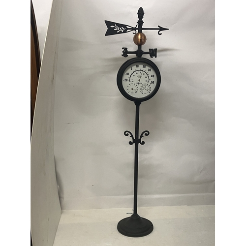 Modern clock barometer and weather vein on metal stand.