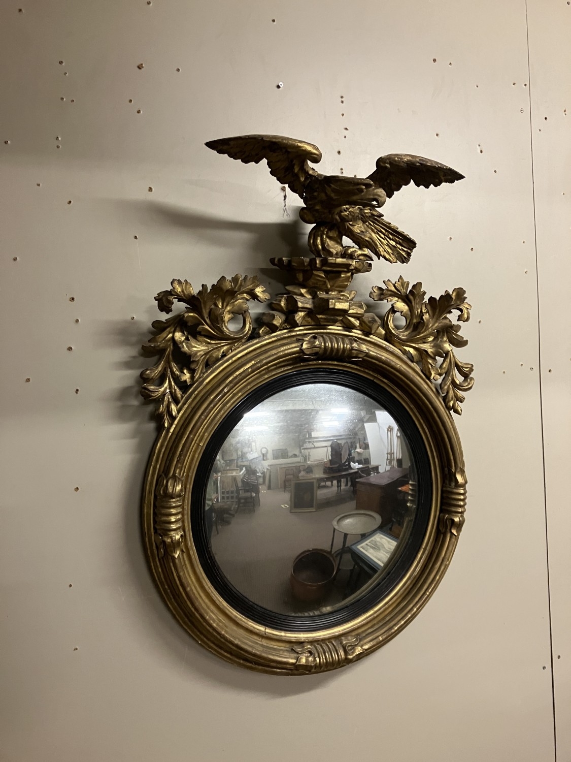 A Regency convex mirror surmounted with a carved eagle, probably Cork.