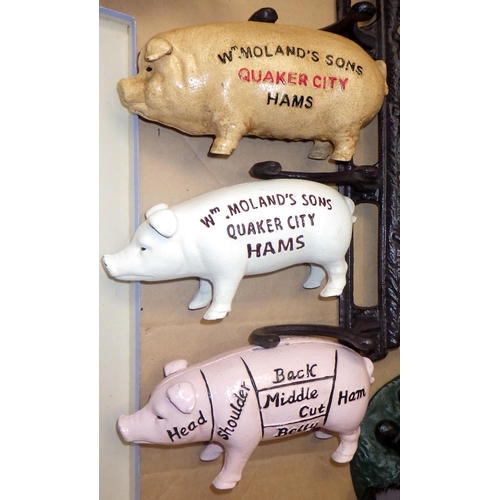 Three cast iron 'city hams' pig moneyboxes together with a golfer door ...
