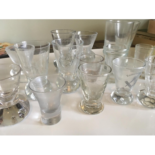 A collection of Masonic shot firing glasses a d other conforming glasses