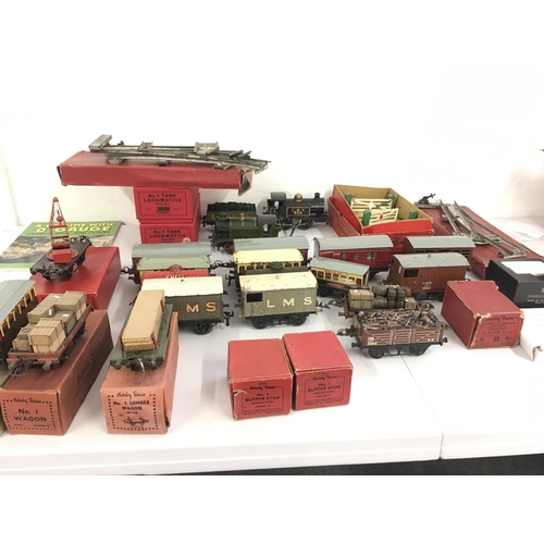 A collection of clockwork tinplate railway locos with numerous wagons ...
