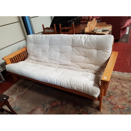 Oak Effect Framed Cream Seat Fold Out Futon Sofa Bed.