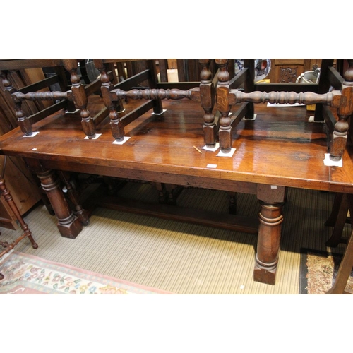 An oak plank top refectory table on cannon barrel legs with single ...