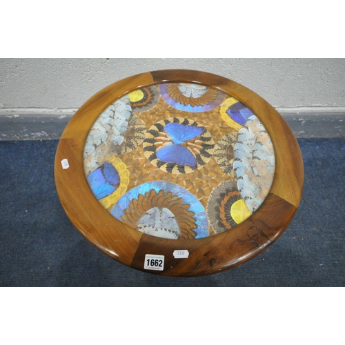 AN AFRICAN HARDWOOD CIRCULAR BUTTERFLY TABLE, the top with lepidoptery ...