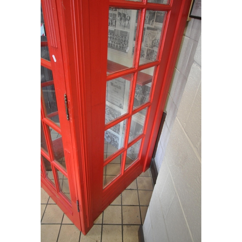 A BESPOKE RED PAINTED PINE TELEPHONE BOX, with a single swing door ...