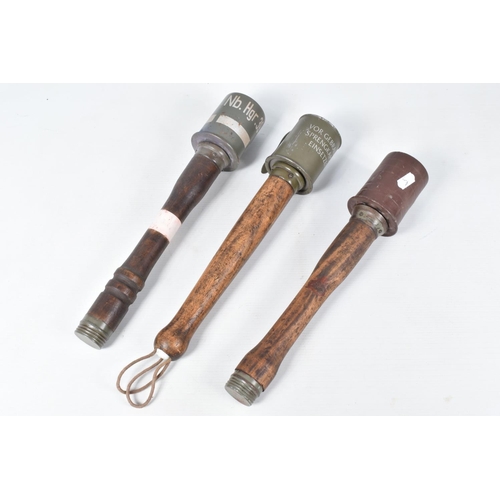 THREE INERT GERMAN STYLE STICK GRENADES, all three have wooden handles ...