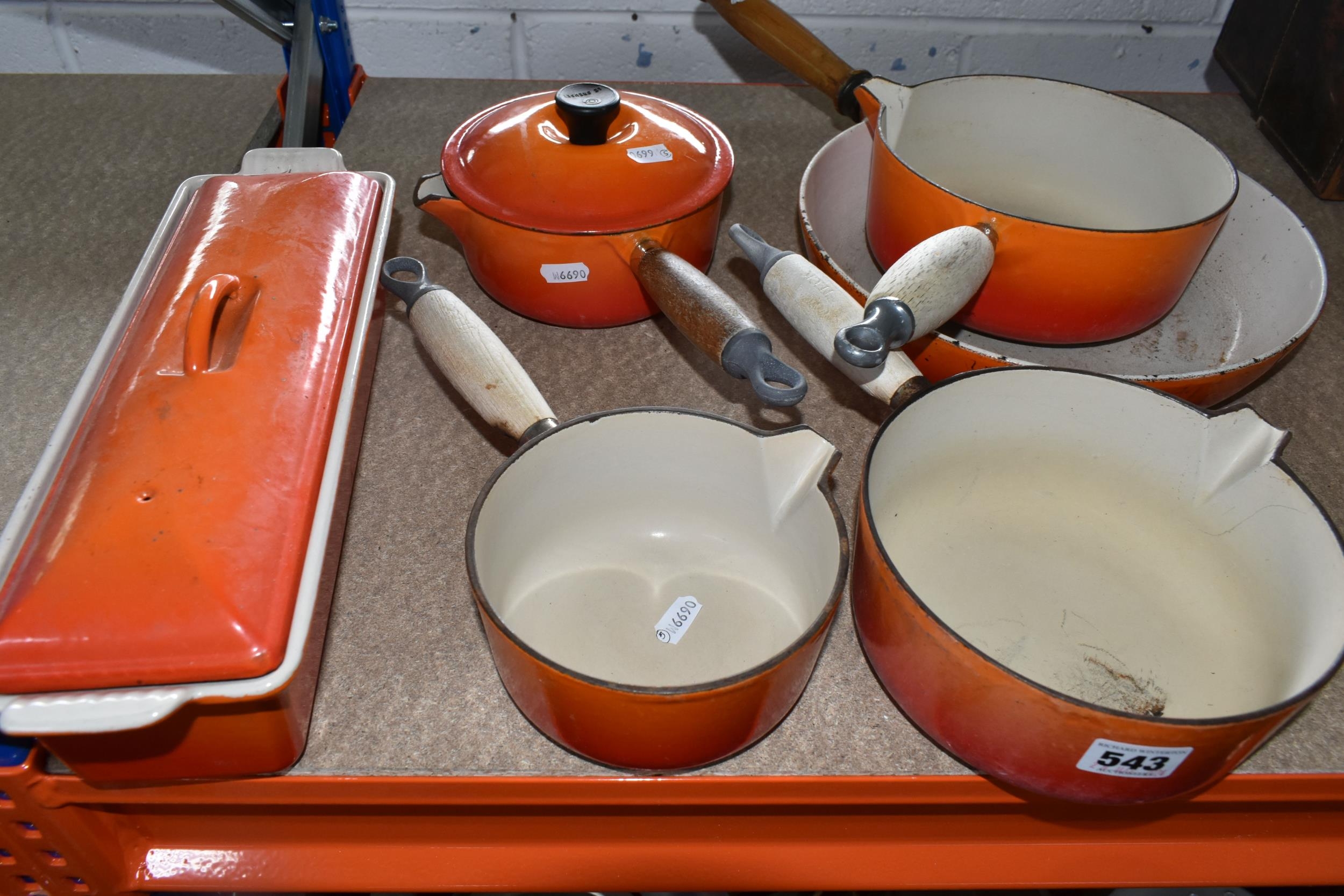 SIX PIECES OF LE CREUSET AND SIMILAR CAST IRON COOKWARE, with orange ...