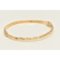 AN 18CT GOLD HINGED BANGLE, twist design, clasp attached with a figure ...