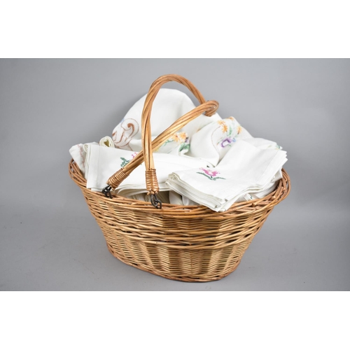A Modern Wicker Basket Containing Embroidered Table Linens