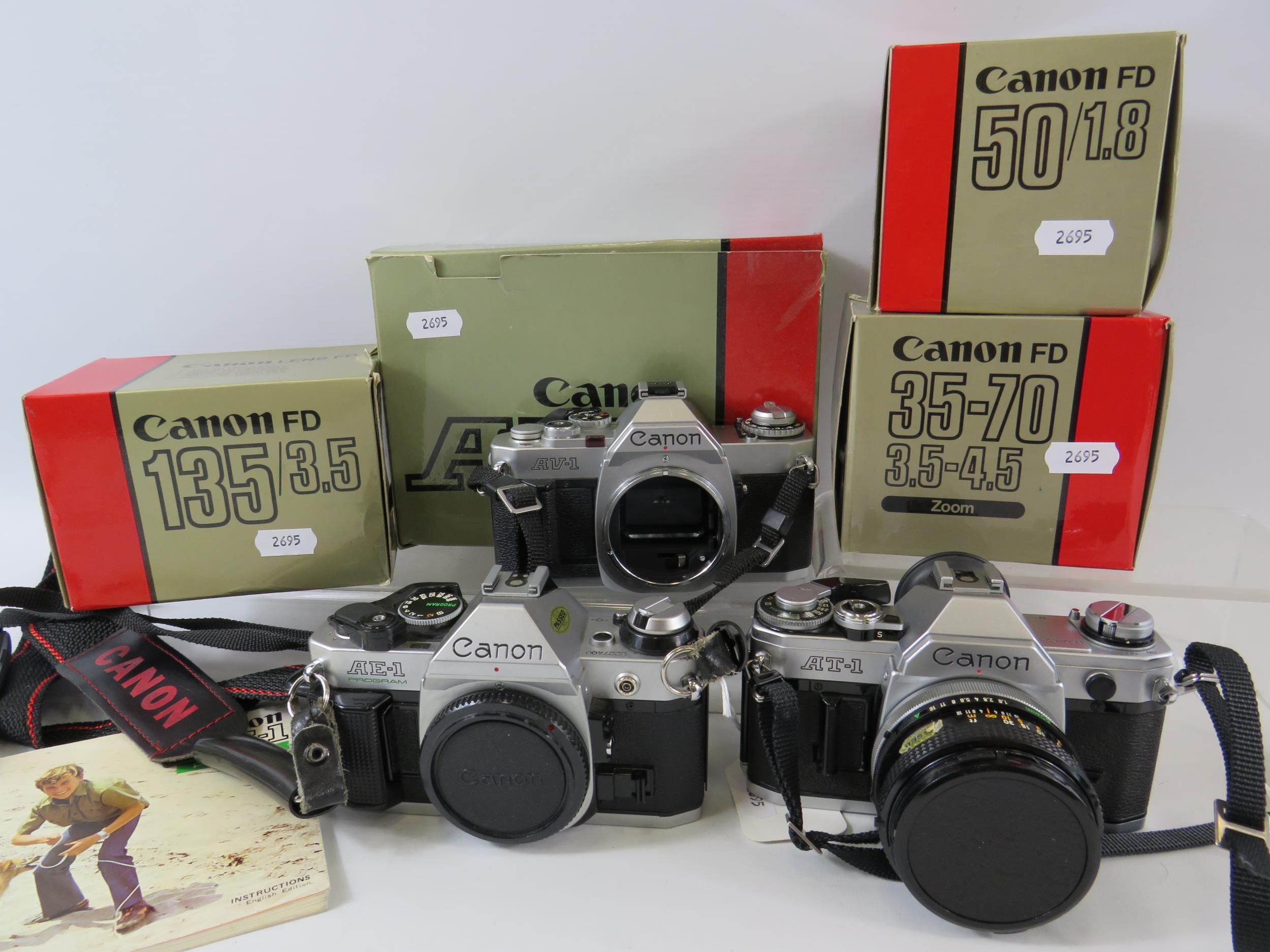 3 Cannon cameras and a selection of lenses.