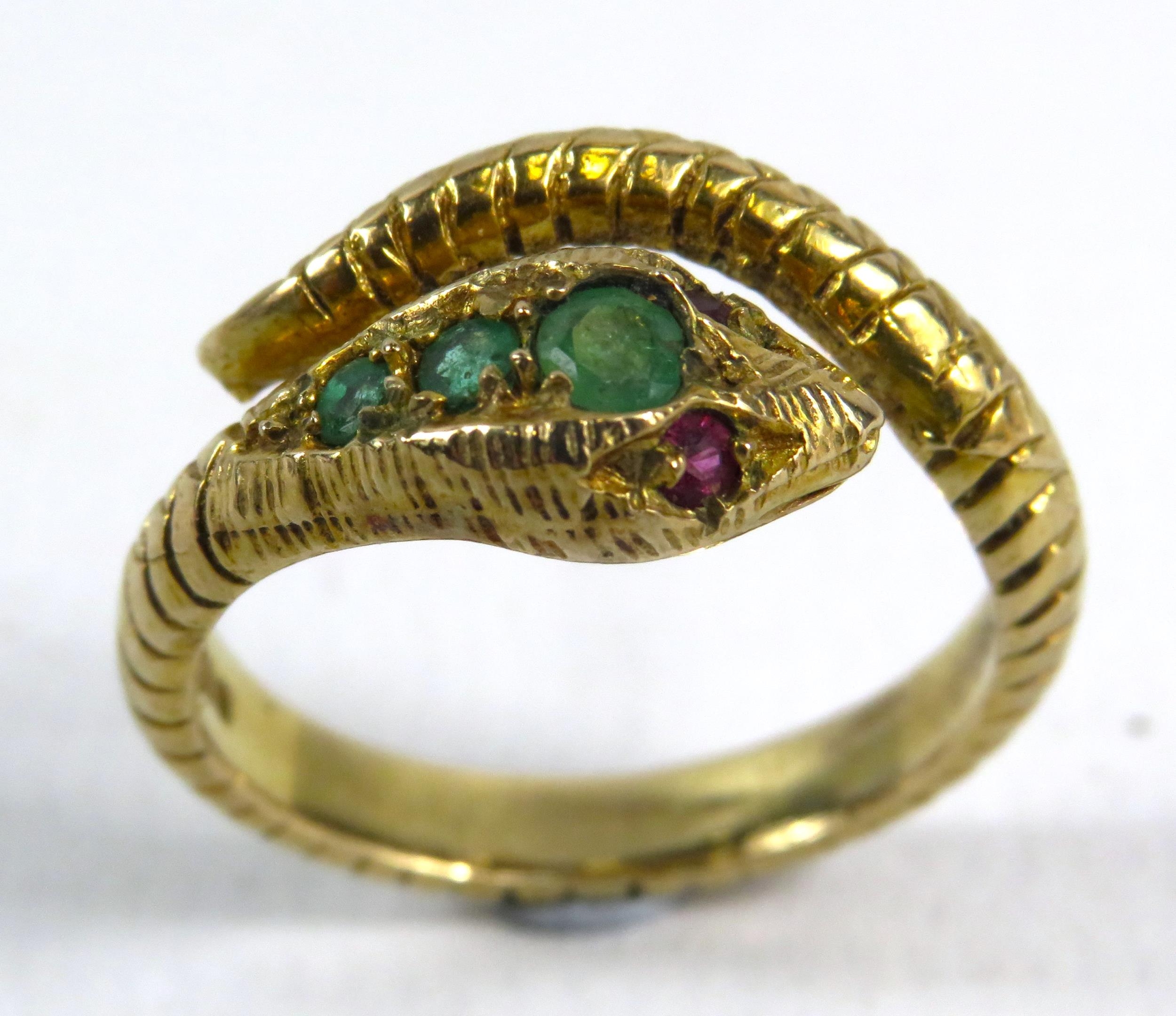 9ct gold Snake ring with ruby eyes and 3 emeralds set to the head, finger size O.5. 5.2grams.
