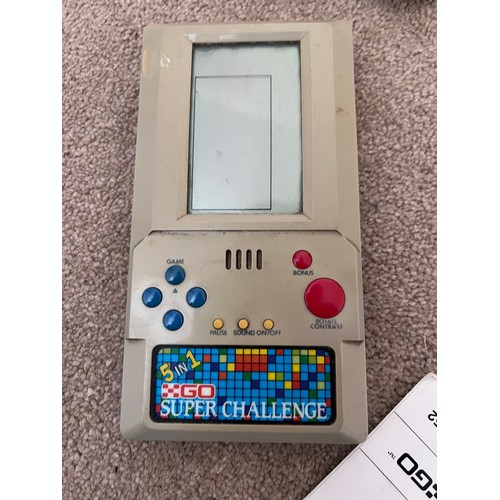 A Go 5-in-1 super challenge handheld game console together with a ...