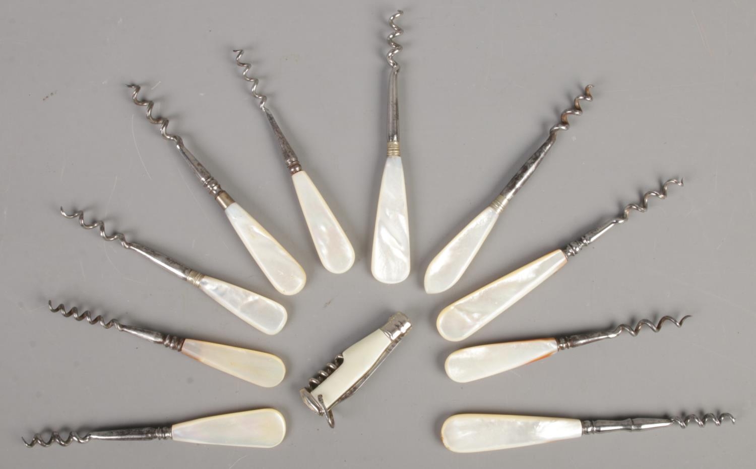 Eleven mother of pearl and white metal perfume corkscrews.