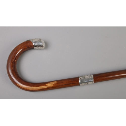 An early 20th century walking cane with silver mounts. Assayed London ...