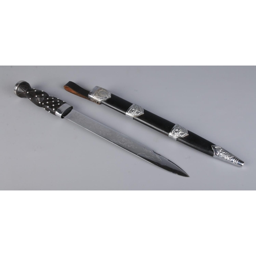 A decorative Scottish dirk, with carved ebonised grip and etched blade ...