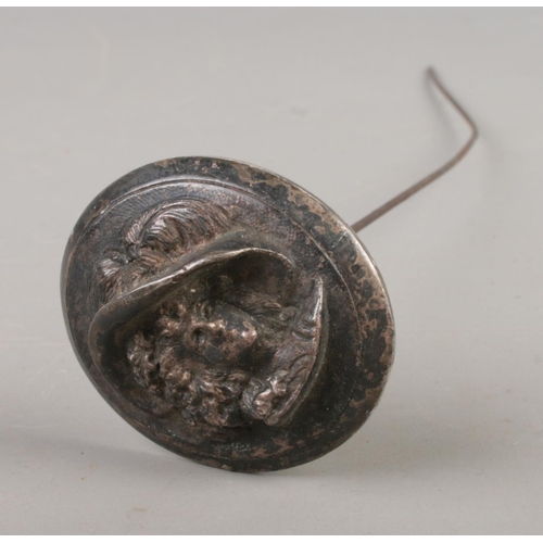 A large silver plated hat pin depicting portrait of hatted maiden ...