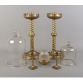 Two pairs of brass candlesticks, the largest with twisted columns ...