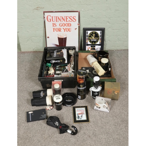 Two boxes containing a good collection of Guinness themed collectables ...