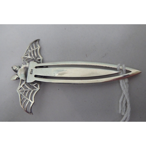A silver coloured metal page marker with a bat finial stamped 925