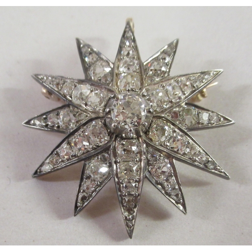 A gold coloured metal and diamond encrusted star design brooch