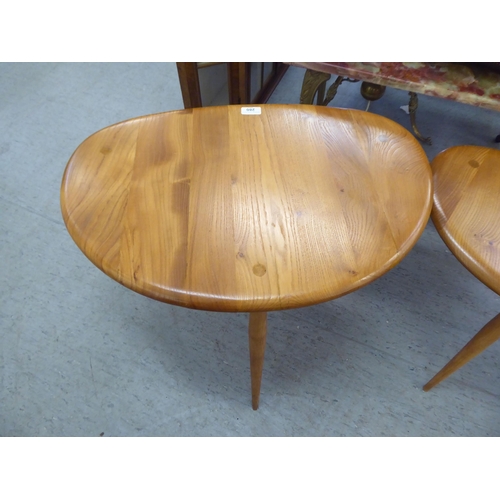 A nesting set of three Ercol light elm pebble tables, raised on turned ...