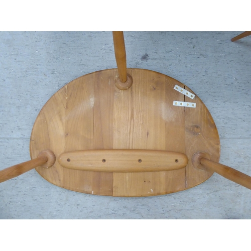 A nesting set of three Ercol light elm pebble tables, raised on turned ...