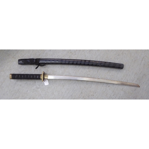 A reproduction of a Japanese Samurai sword with a rope clad handle the ...