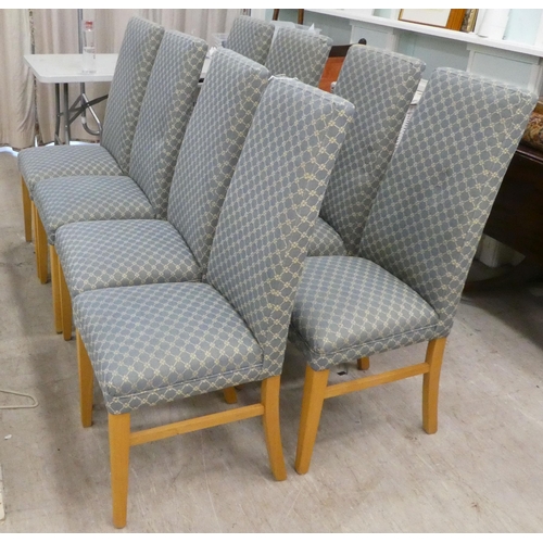 A set of eight modern fabric covered dining chairs, raised on beech legs