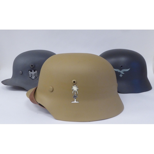 Three various German World War II design, military steel helmets with ...