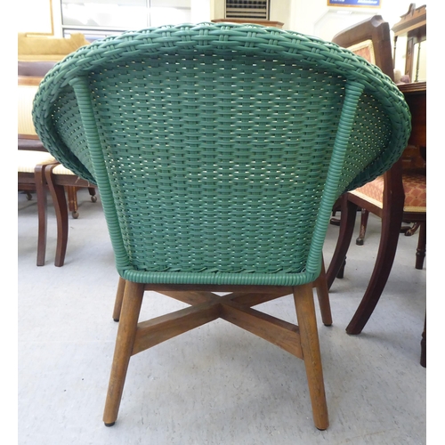 A modern Indonesian made green wicker style easy chair, on a teak ...
