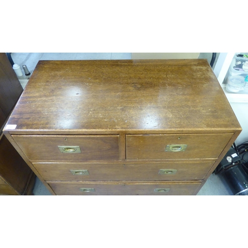 An early 20thC oak two part, campaign style chest, the two short/three ...