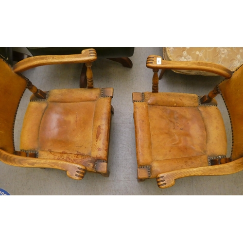 A pair of 1930w oak framed chairs with brown hide upholstered backs and ...