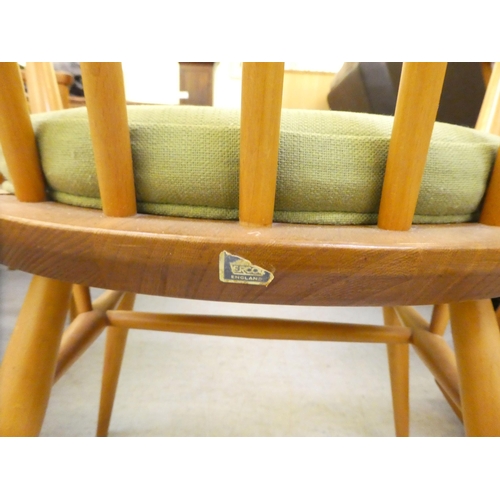 An Ercol honey coloured beech and elm framed, high hoop and spindled ...