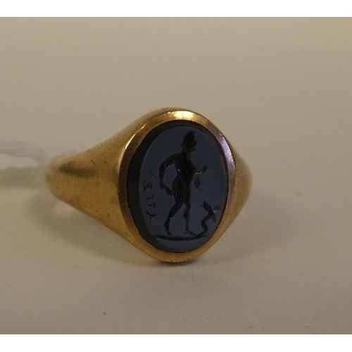 A gentleman's 9ct gold signet ring, set with a carved grey stone tablet